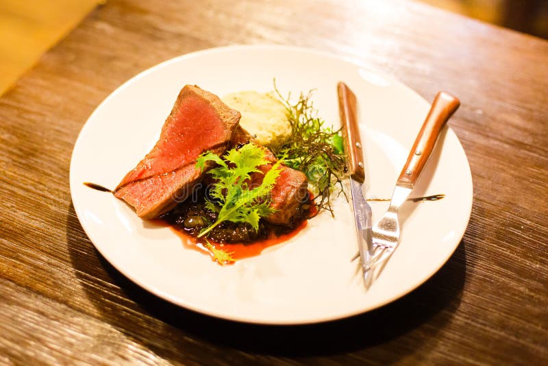 The Side View of the Delicious Meat in Blood with Greens. Stock Photo ...