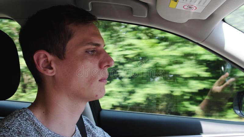 Side View of the Driver. Young Man Driving a Moving Car, Trees ...