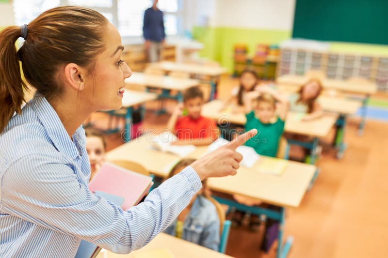 Elementary School Teacher Pointing in Class Stock Image - Image of ...