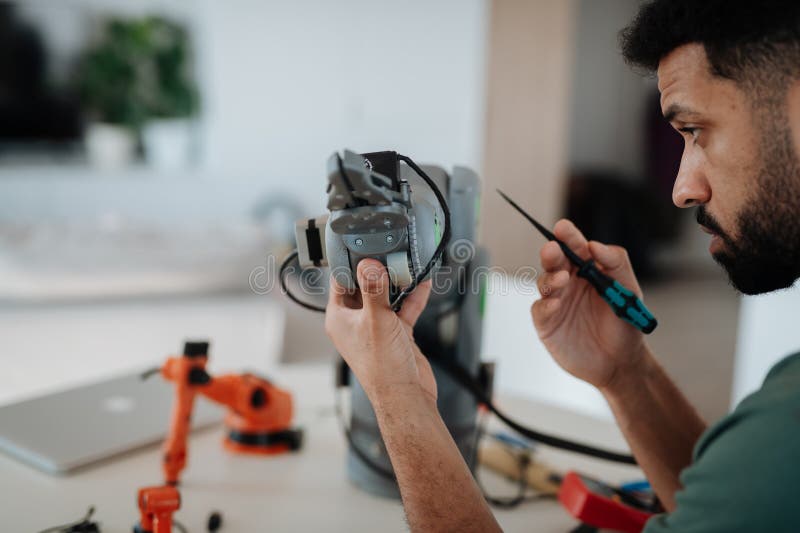 Side View of Engineer Building and Programming a Robotic Arm at Home. Stock Image - Image of ...