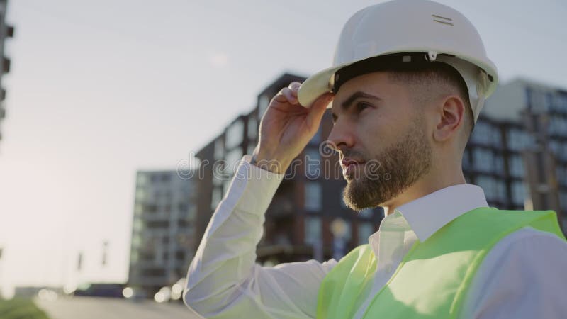 Side View of the Engineer Standing, Trying on the Hard Hat Outside ...