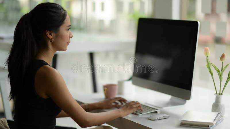 Side View of Female Office Worker Working with Computer on Worktable ...