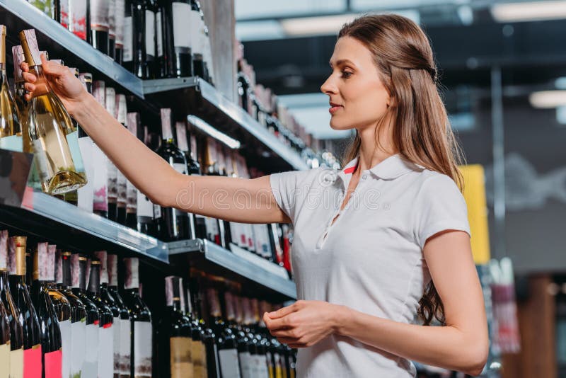 Side View of Female Shop Assistant with Bottle of Wine Stock Image ...