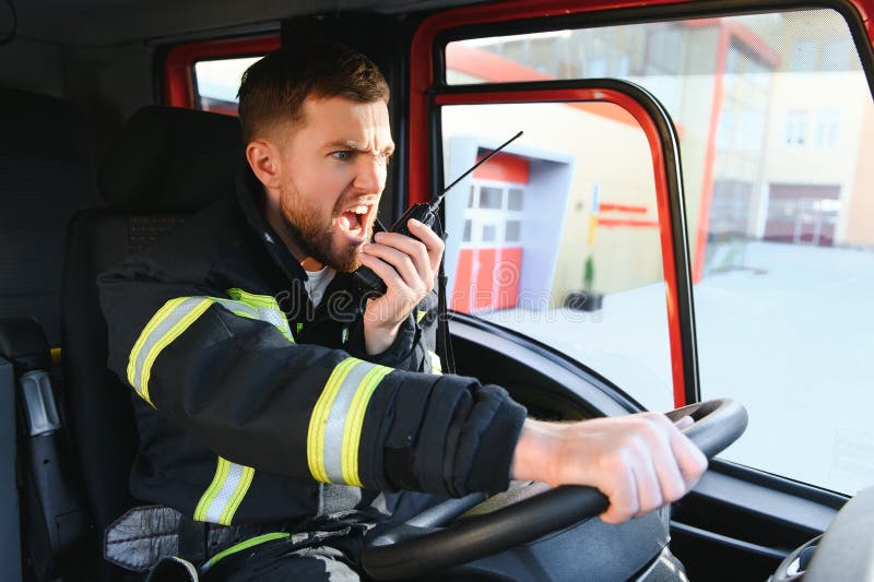 Side View of Firefighter in Protective Uniform Driving Fire Engine ...