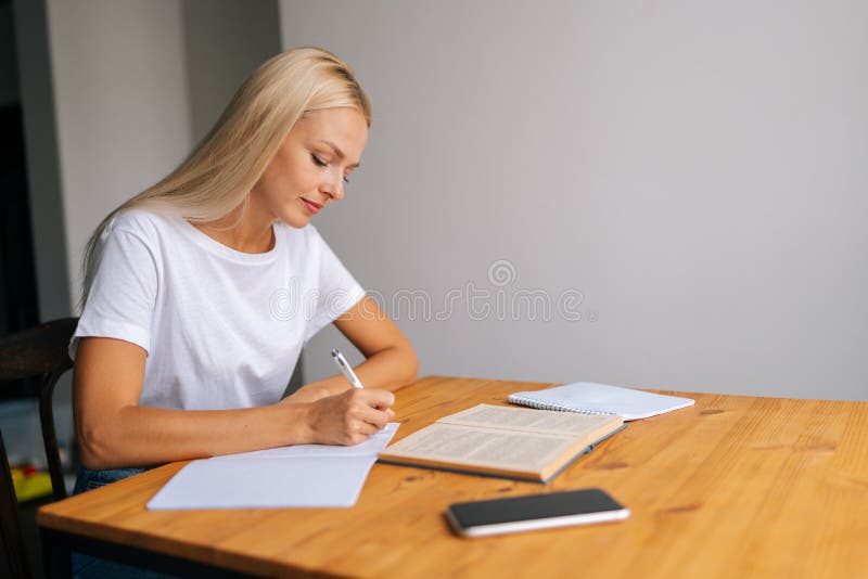Side View of Focused Blonde Female Student Learning Making Notes ...