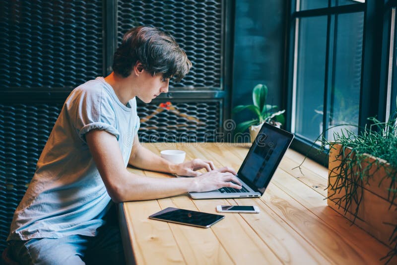 Serious Man Browsing Laptop Located on Wooden Table with Gadgets Stock ...