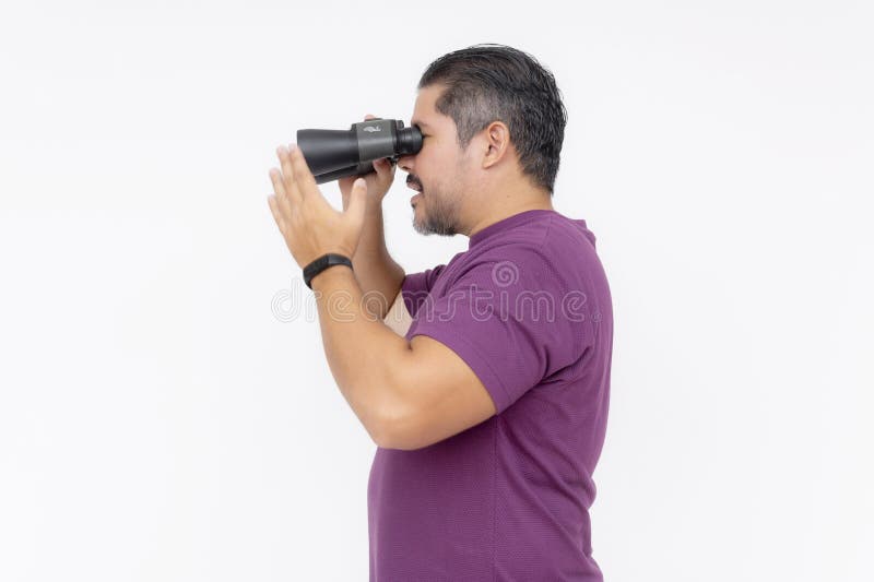 Side View of a Focused Man Holding Binoculars, Searching or Observing ...