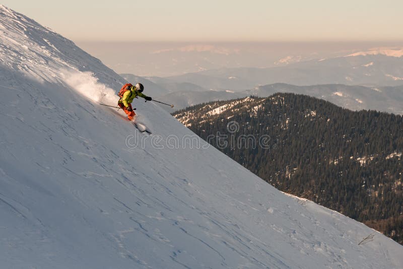 Side View of Freerider Sliding Down Snow-covered Slope Against Backdrop ...