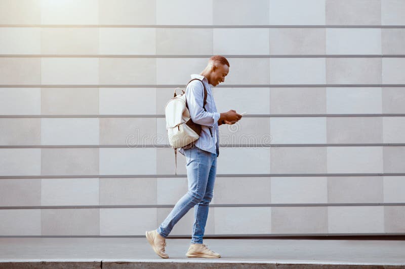 Side View of Cool Black Guy Walking Along City Street and Using ...
