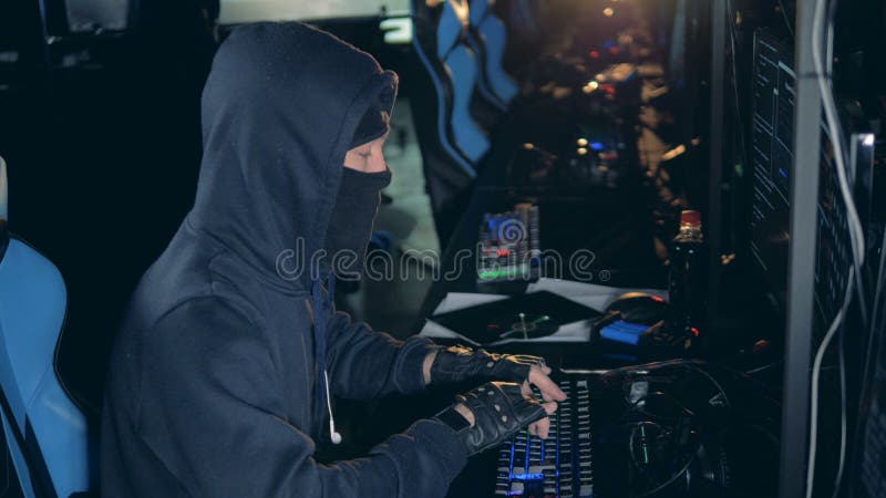 Side View of a Hacker in Disguise Working with Computers Stock Footage ...