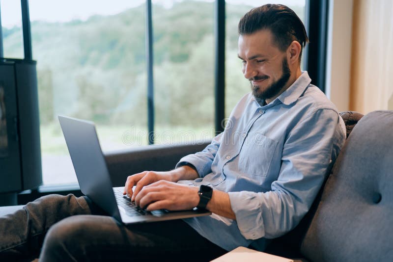 Side View of Handsome Man Using Laptop, Typing on Keyboard and Laughing ...