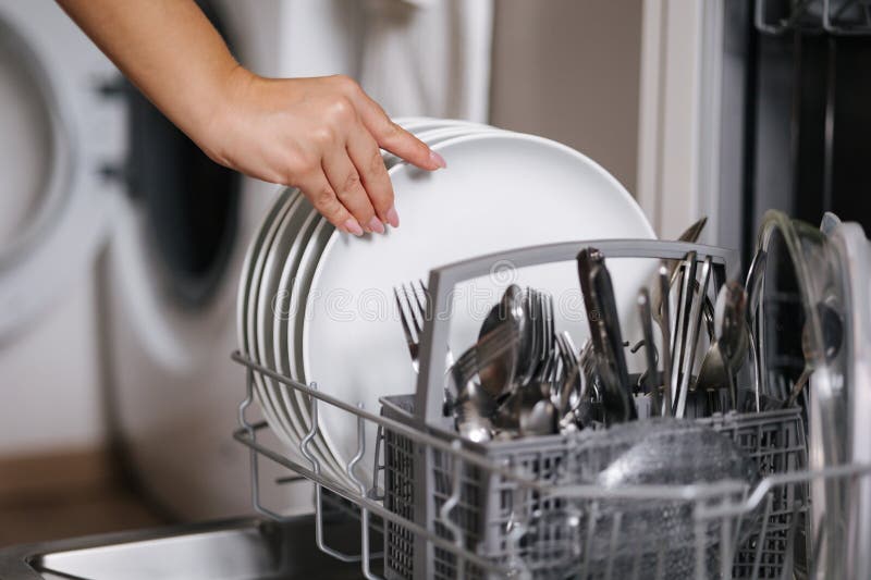 Side View of Human Hand Removing Clean Plates from a Loaded Dishwasher ...