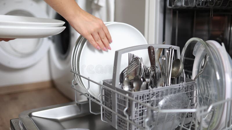 Side View of Human Hand Removing Clean Plates from a Loaded Dishwasher ...