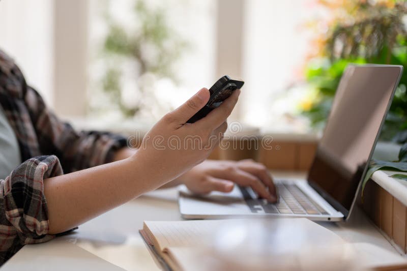 Side View Image of a Female Freelancer Using Her Smartphone and Laptop ...