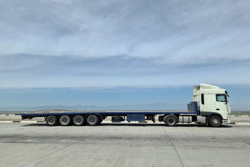 Side View of a Large Length Cargo Big Truck with Copy Space on a Blue ...