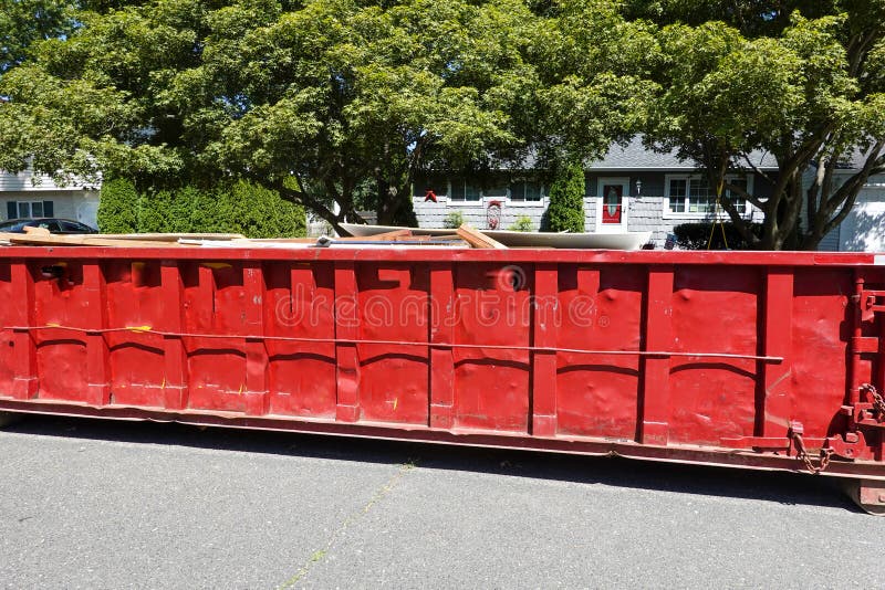 Side View of a Large Red Beat Up Dumpster on the Street by a Curb in a ...