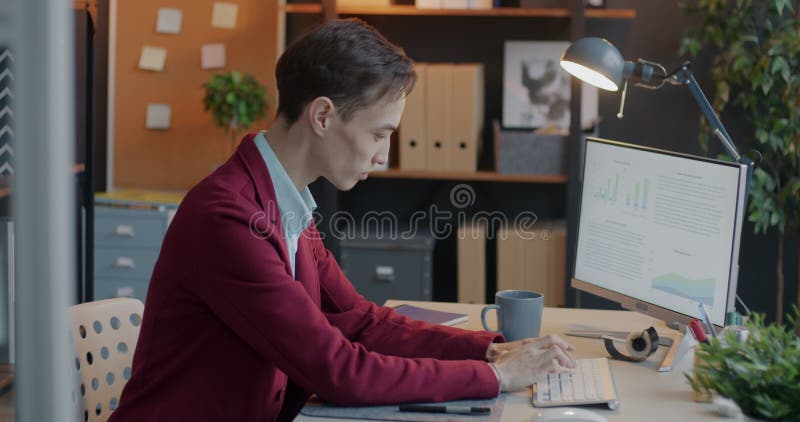 Side View of Male Employee Using Personal Computer Typing Focused on ...
