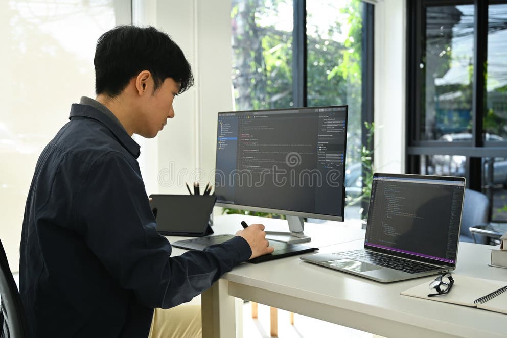 Side View of Male Programmer Sitting Front of Computers with Coded Data ...