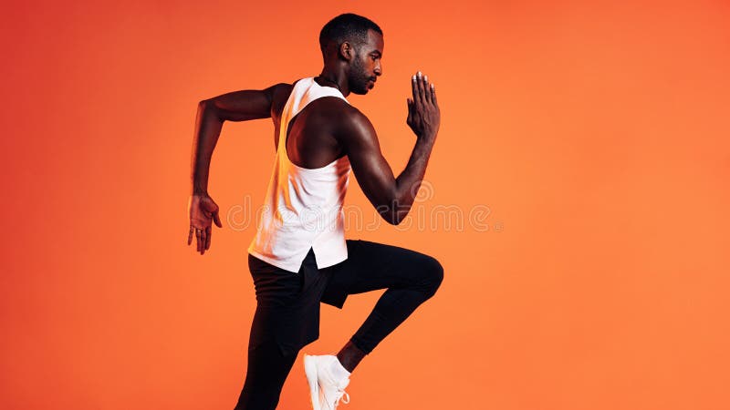 Side View of a Male Runner Sprinting Over Orange Background Stock Image ...