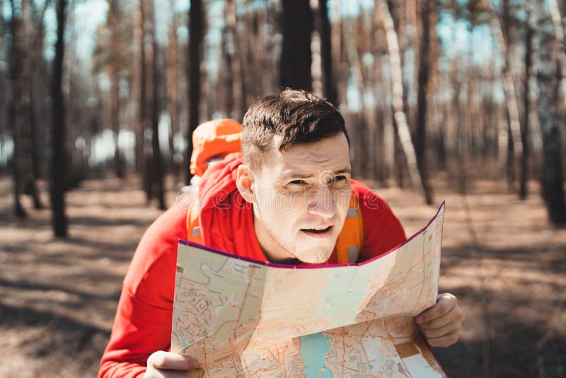Traveling Man with Map in Woods. Side View of Man with Backpack Reading ...