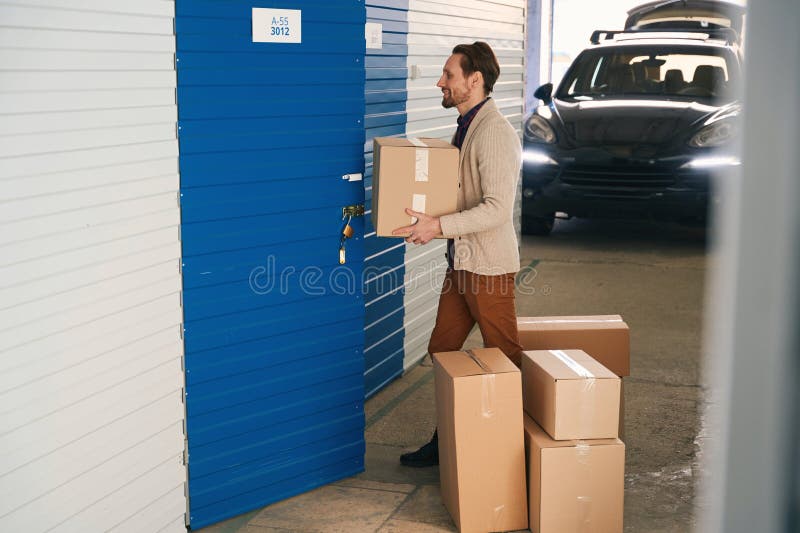 Side View of Man with Big Cardboard Boxes in Self Storage Unit Stock ...