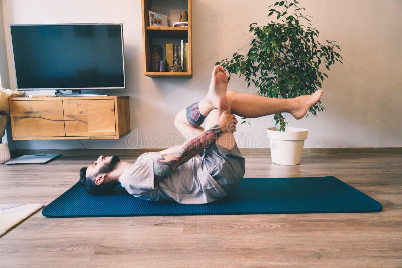 Side View Man Doing Yoga on the Floor Practicing Wind Relieving Pose ...