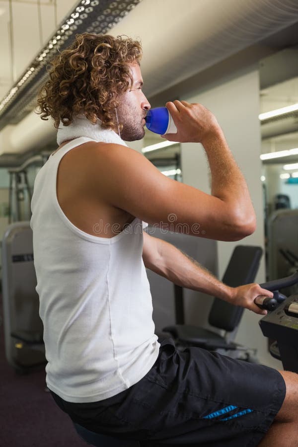 Side View of Man Drinking Water on Exercise Bike at Gym Stock Image ...