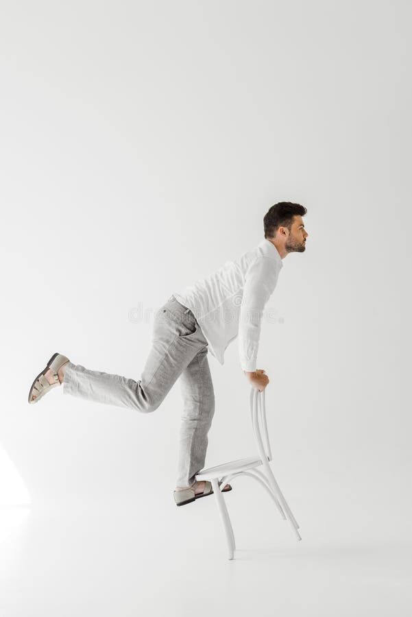 Side View of Man in Linen Clothes Balancing on Chair Stock Image ...
