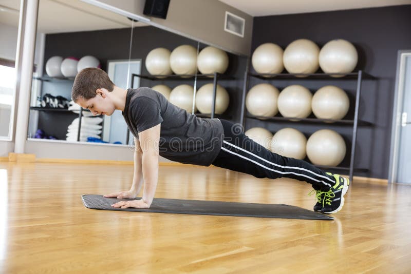 Side View of Man Performing Pushups on Mat in Gym Stock Photo - Image ...