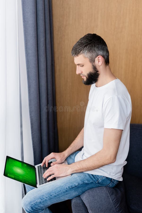Side View of Man Using Laptop with Charts and Graphs on Screen Stock ...