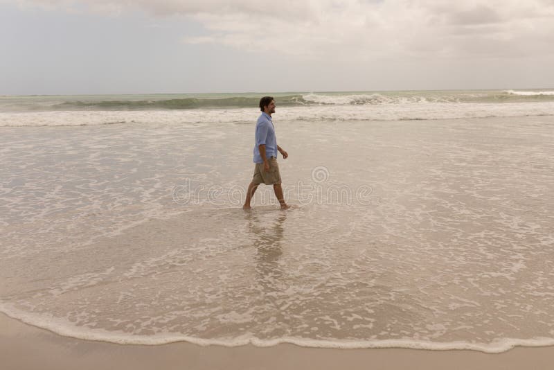 Side View of a Man Walking on the Beach Stock Photo - Image of looking ...