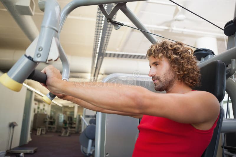 Side View of Man Working on Fitness Machine at Gym Stock Image - Image ...