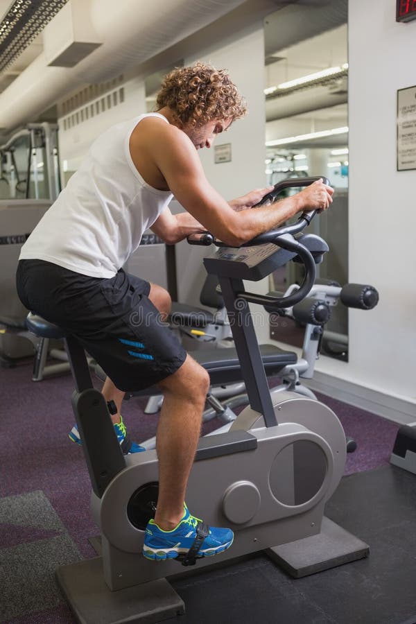 Side View of Man Working Out on Exercise Bike at Gym Stock Image ...