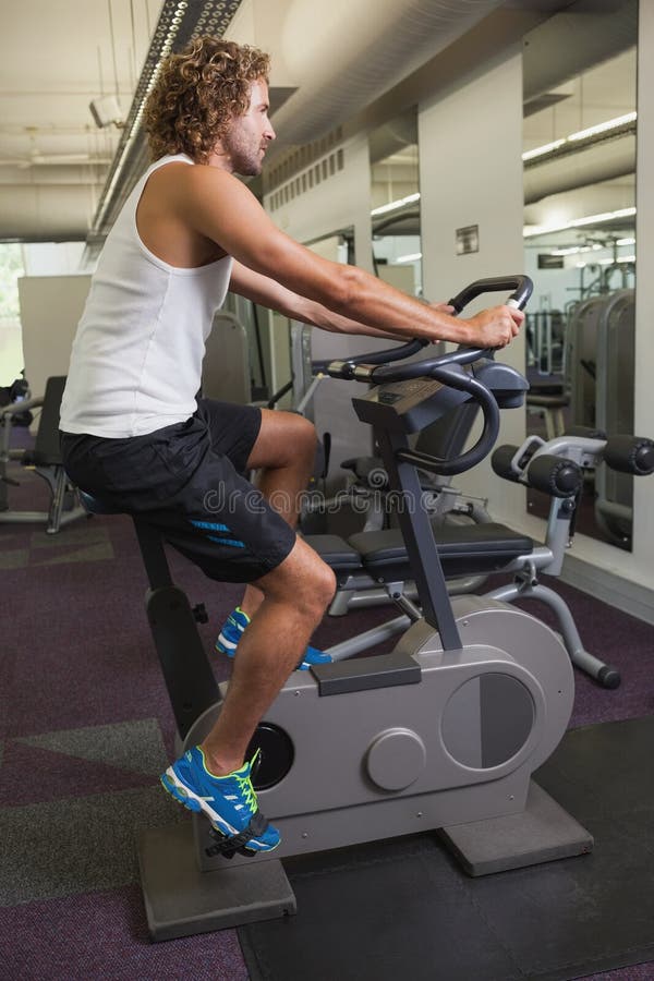 Side View of Man Working Out on Exercise Bike at Gym Stock Photo ...