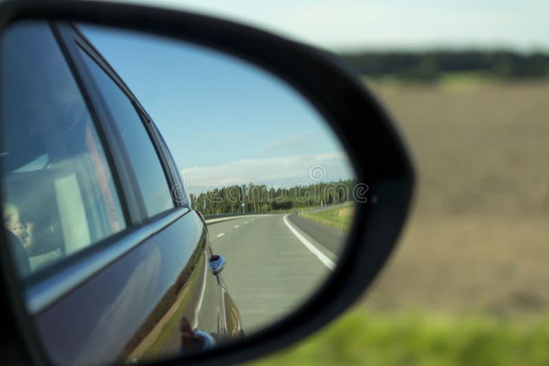 Side View Mirror Reflection of Two-lane Winding Road in Forest. Baby ...