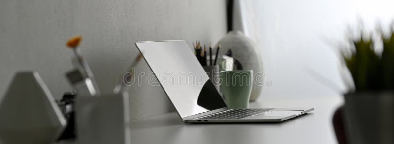 Side View of Modern Office Desk with Laptop, Painting Tools and ...
