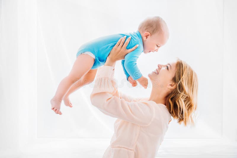 Side View of Mother Raising Up Her Stock Image - Image of indoors ...