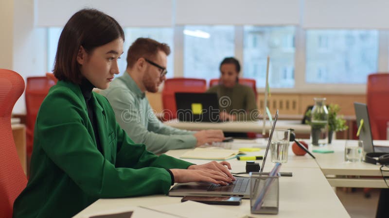 Side View of Multiethnic Developers Coding Laptop in Modern Office ...