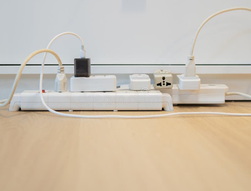 Side View of Multiple Electrical Plugs on Wooden Floor Near by the ...