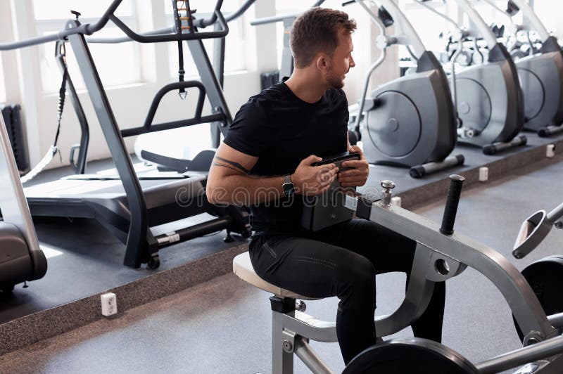 Side View on Muscular Man Taking Break after Training on Machine Stock ...