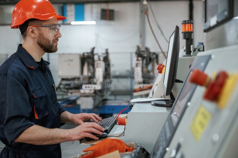 Side View, Operating the Machine. Factory Worker is Indoors with Hard ...