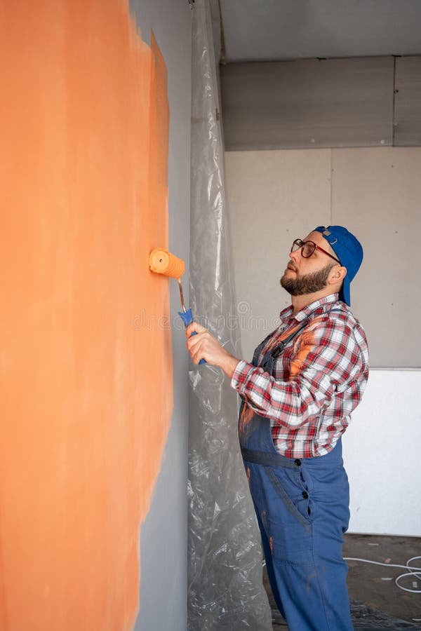Side View of Painter Man Painting the Wall, with Paint Roller on Big ...