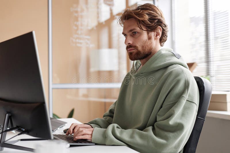 Man Wearing Hoodie and Using Computer in it Development Office Stock ...