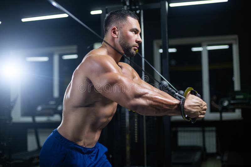 Side View Portrait of a Bodybuilder Working on His Chest Muscles with ...