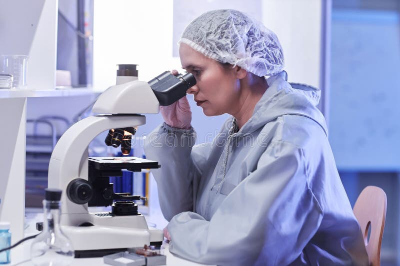 Side View Female Scientist Looking in Microscope in Laboratory Stock ...
