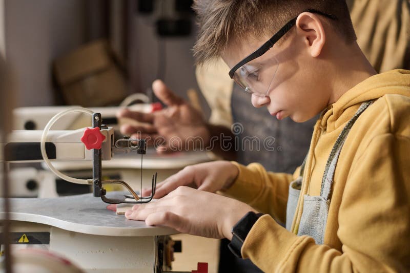 Focused Boy Cutting Wood Using Machine Tools in Carpentry Workshop ...