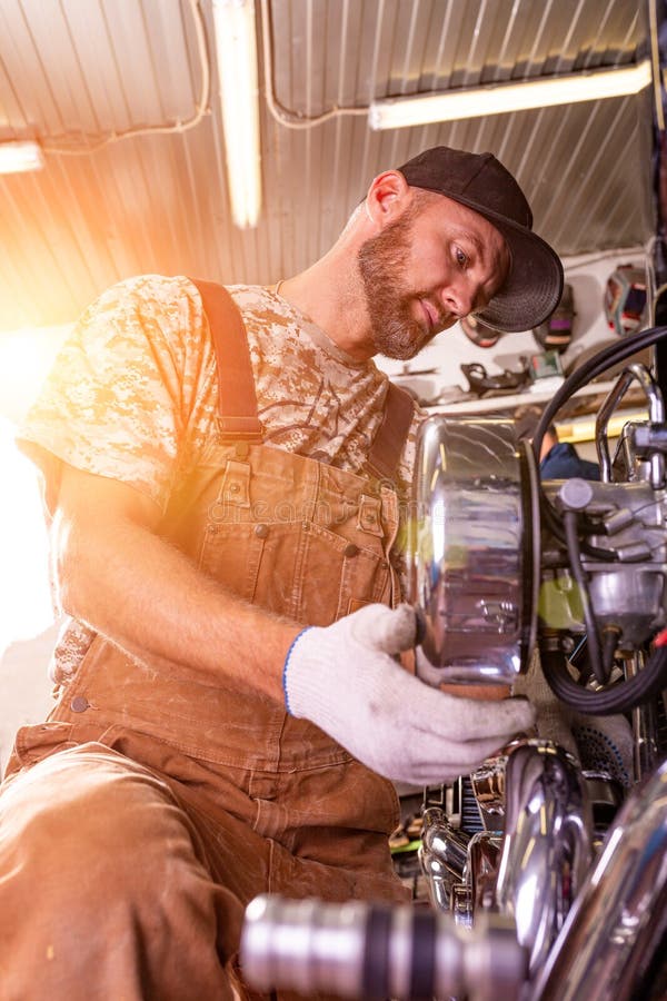 Side View Portrait of Man Working in Garage Repairing Motorcycle Stock ...