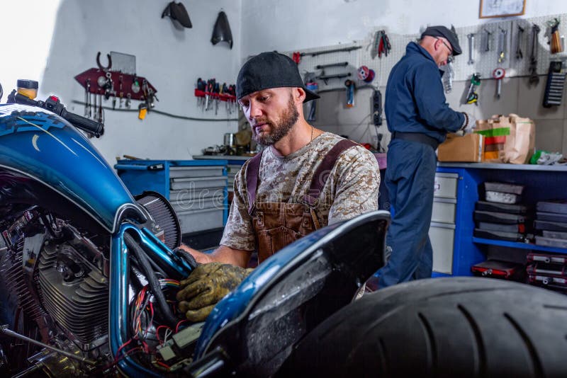 Side View Portrait of Man Working in Garage Repairing Motorcycle Stock ...