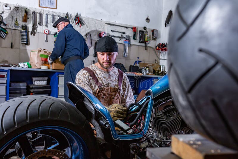 Side View Portrait of Man Working in Garage Repairing Motorcycle Stock ...