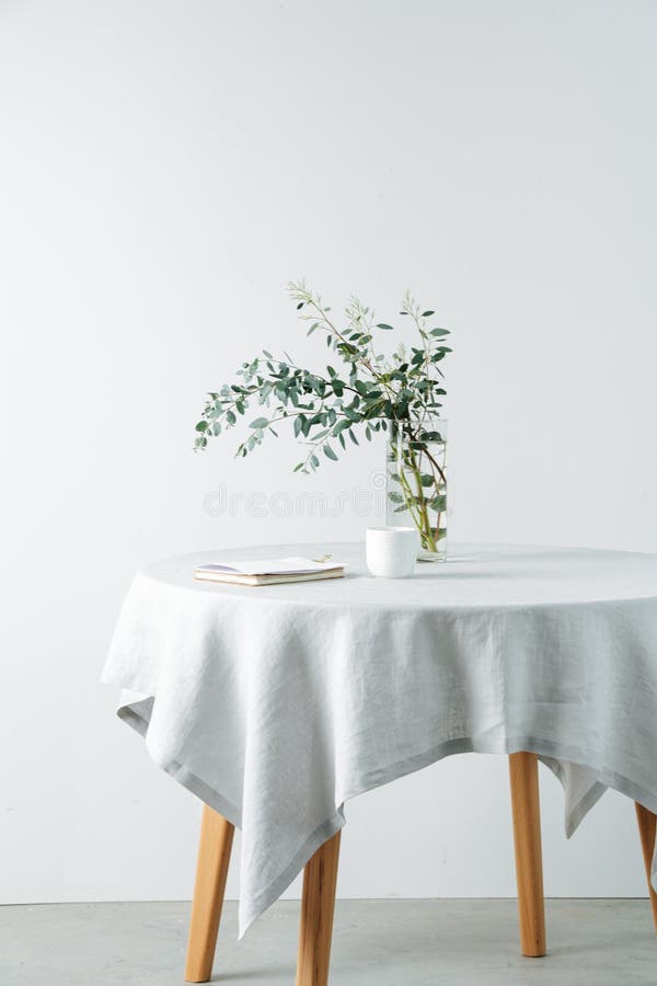 Side View Round Table with a Rough White Tablecloth and Branch in a Jar ...